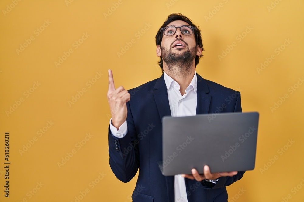 Foto de Handsome latin man working using computer laptop amazed and ...