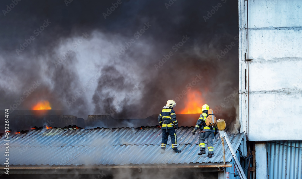 Firefighters at work. Several man are engaged in extinguishing fire ...