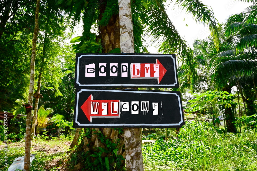 A wooden sign painted in black with red arrow pointing to the right ...