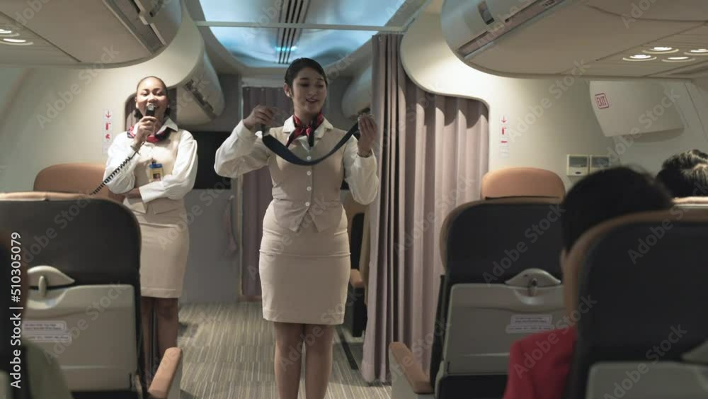 Two woman flight attendants in uniform standing explain and ...