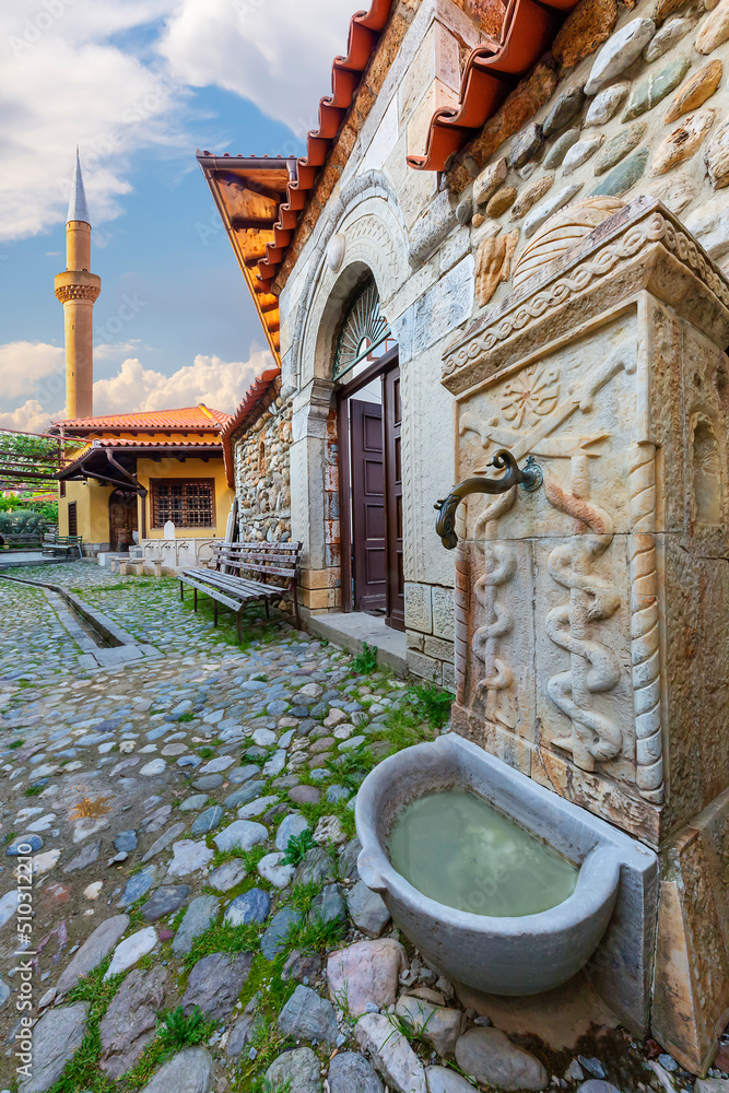 Old fountain of the Sufi temple with the minaret of Halveti’s Tekke ...