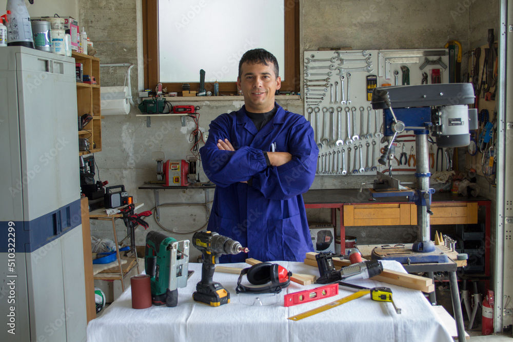 Image of a handyman in his workshop with a table in front of work tools ...