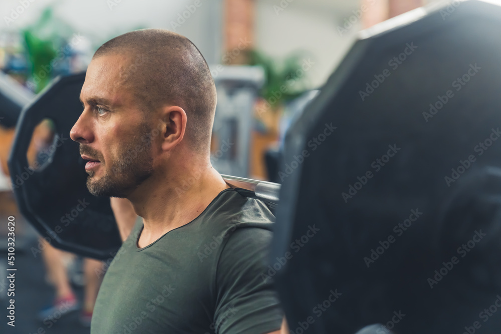 Hairless european attractive middle-aged man lifting very heavy barbell ...