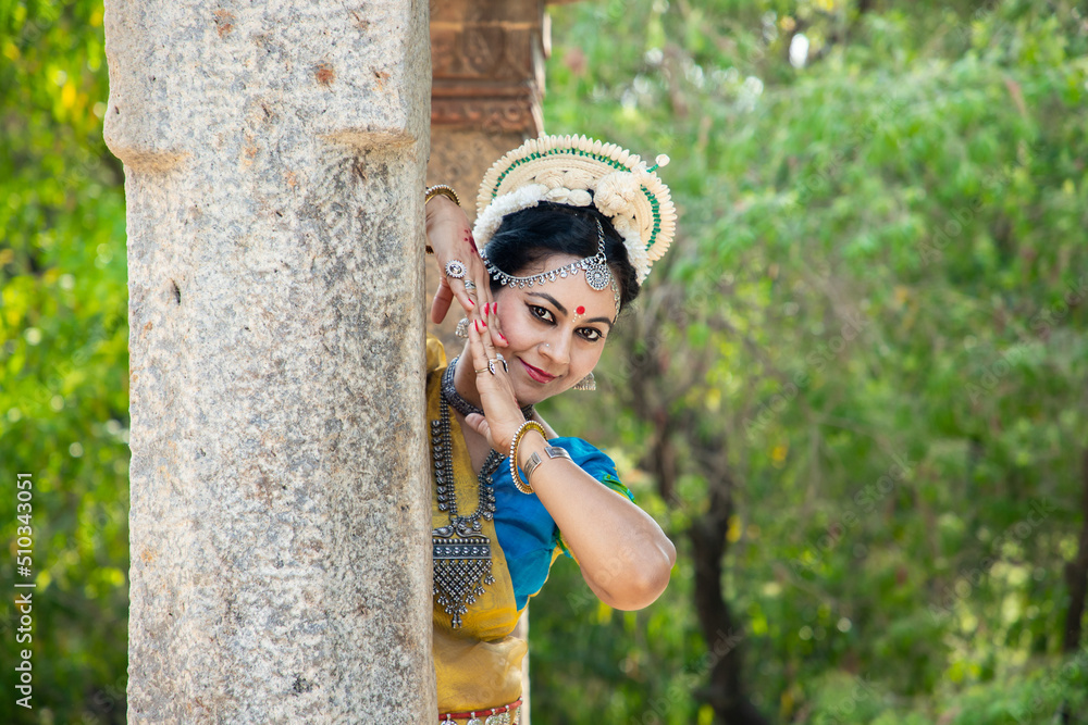 Indian woman Odissi dancer doing classical dance form outdoor at nature ...