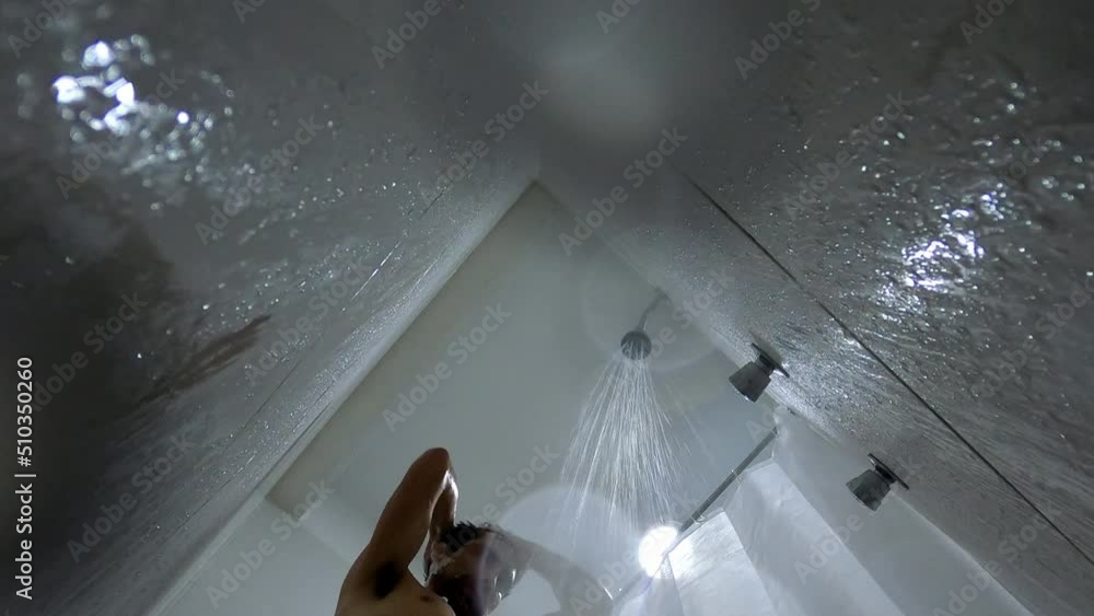low angle view of a man taking a shower in a hotel room seen from below ...