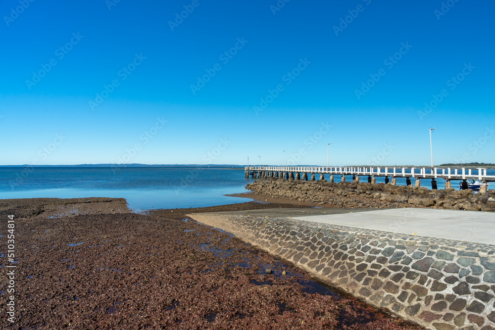 View past boat ramp and jetty to the blue waters of Moreton Bay, at ...