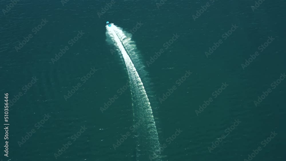 Luxury boat in dark color, fast movement on blue water, aerial view ...