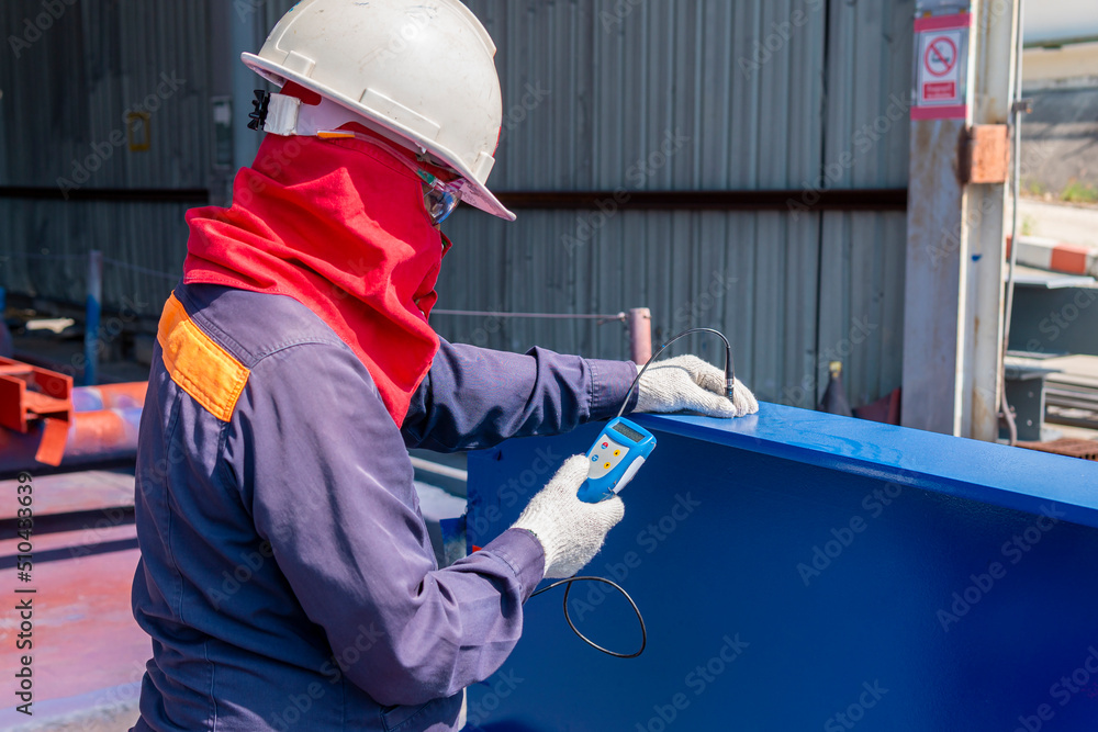 Technicians are measuring the Dry Film Thickness (DFT) for a painting ...