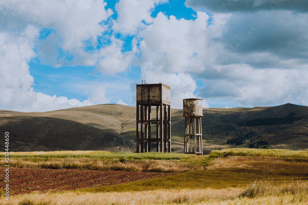Photograph of two water tanks in a rural landscape in Peru. Concept of ...