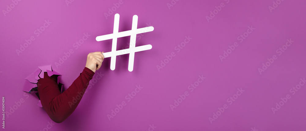 hand holding hashtag sign over pink background, social media concept ...
