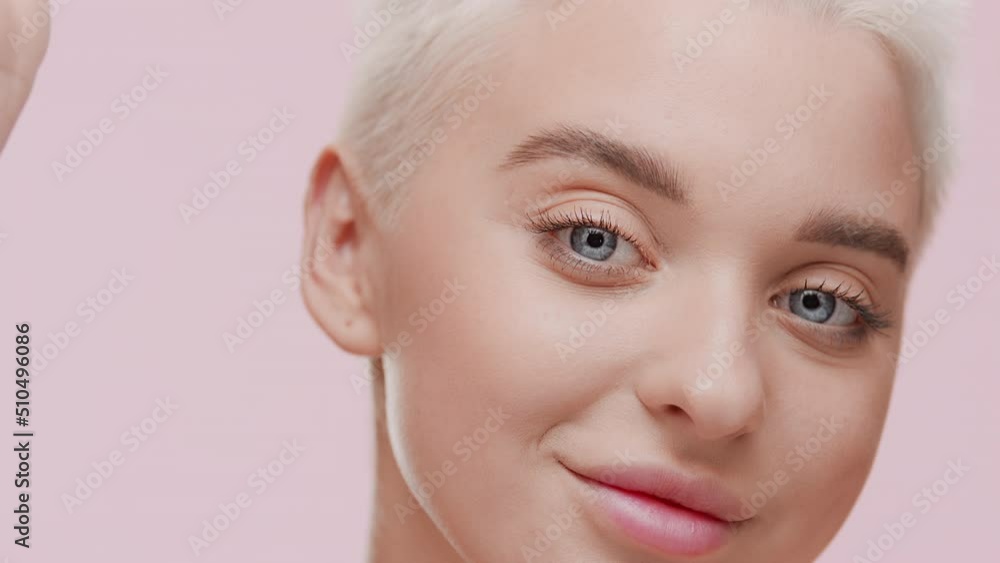 Gorgeous young slim blonde Caucasian woman touches her cheek tapping ...