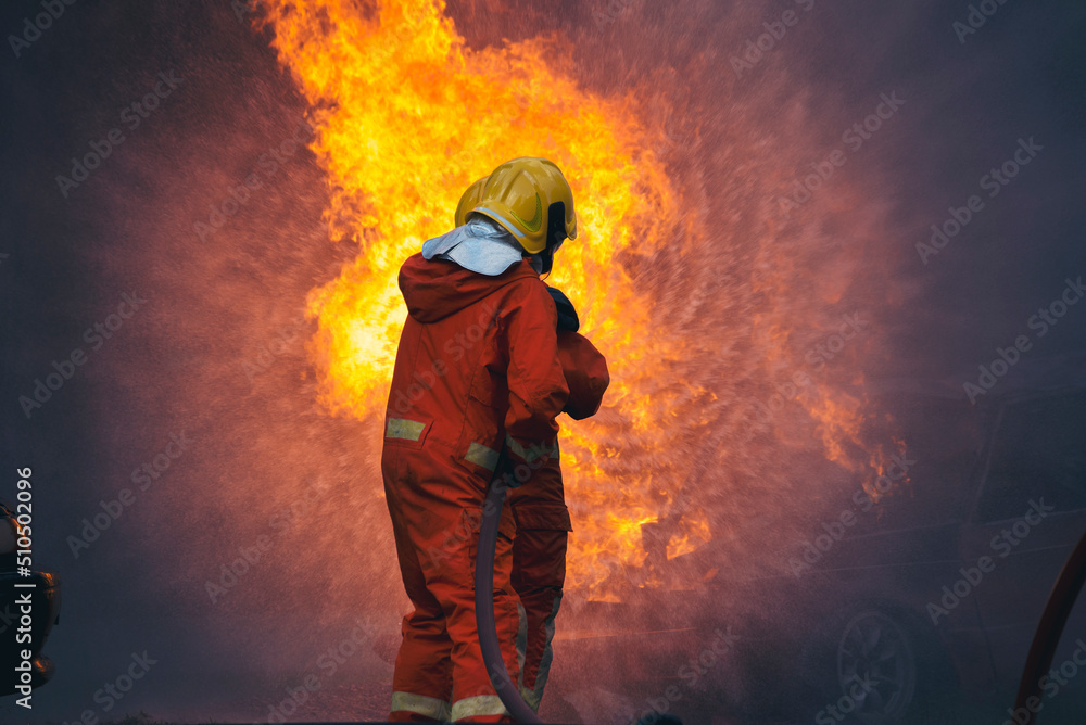 Firefighter fighting with flame using fire hose chemical water foam ...