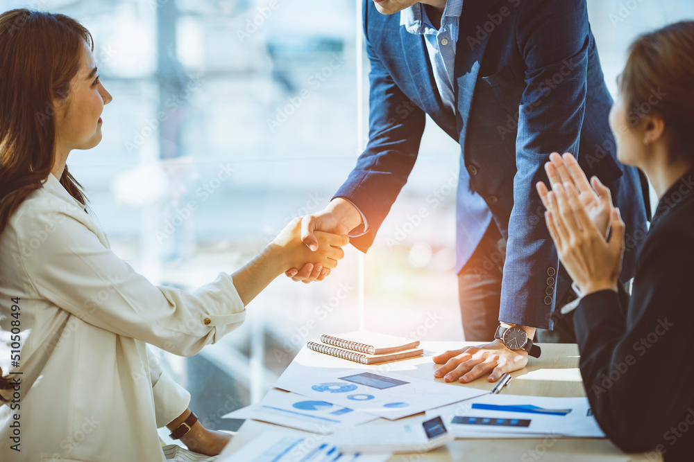 Business people shake hands while finishing up meetings or negotiations ...