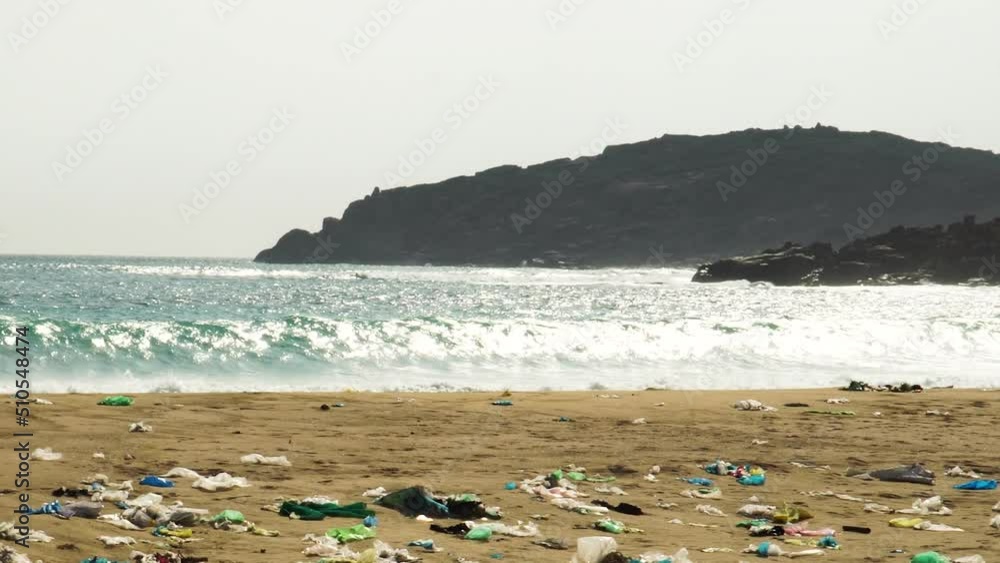 ocean waves crashing in to dirty polluted plastic trash waste sandy ...
