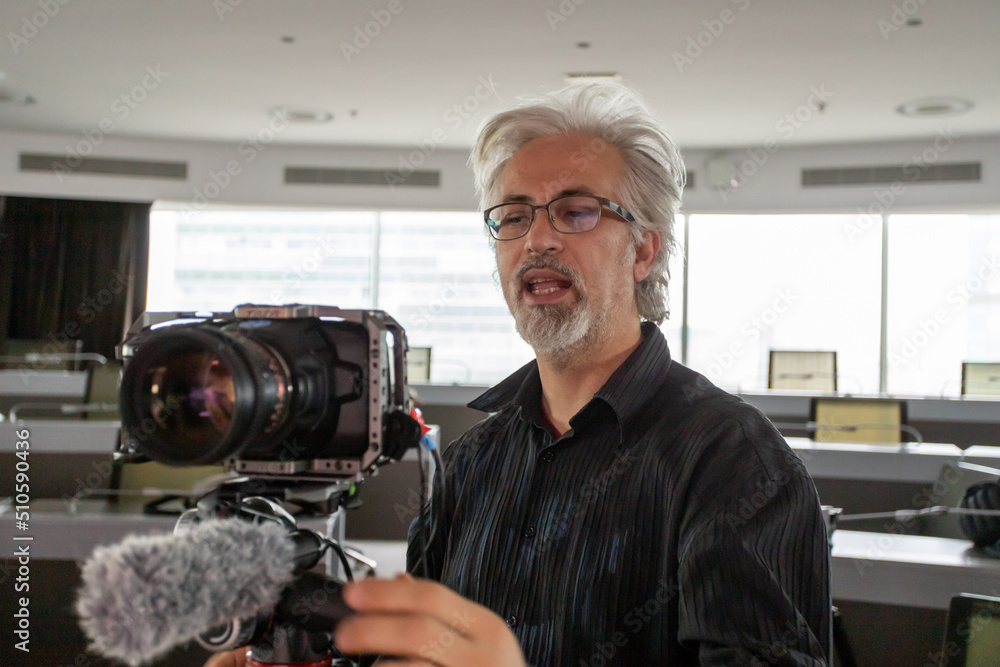 Film director with the film camera ready to start work inside a filming ...