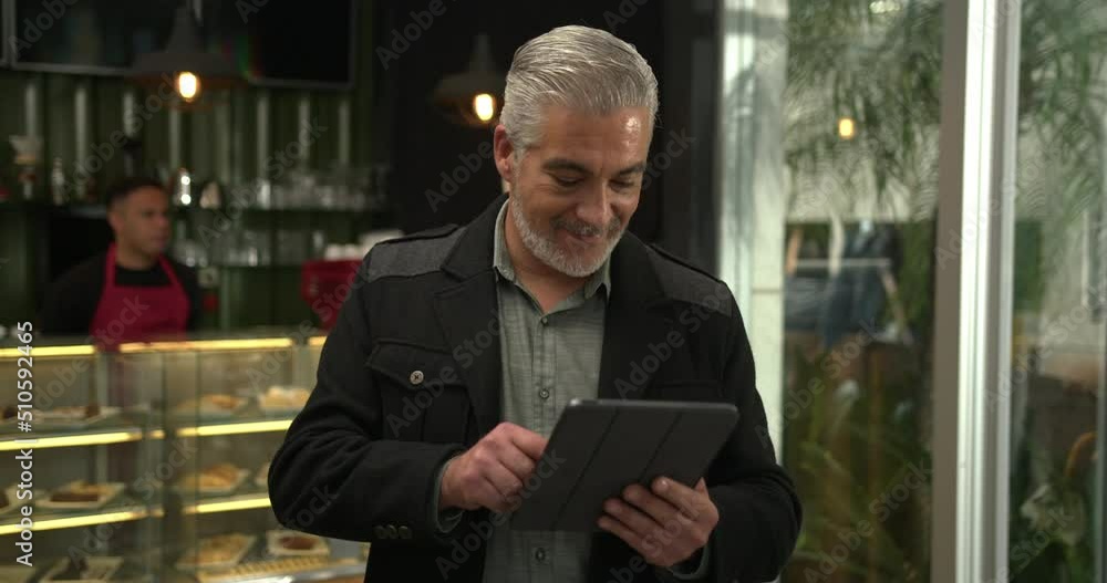 Vidéo Stock Older business man holding tablet inside cafe. Owner of ...
