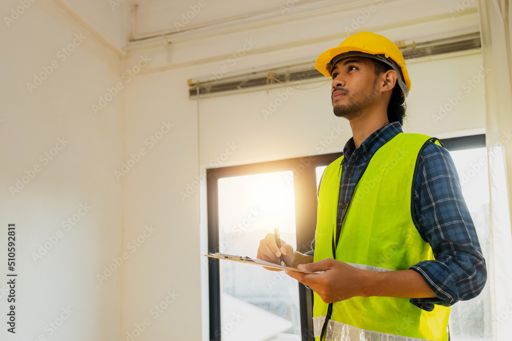Asian inspector wear safety vest and checking list into clipboard ...