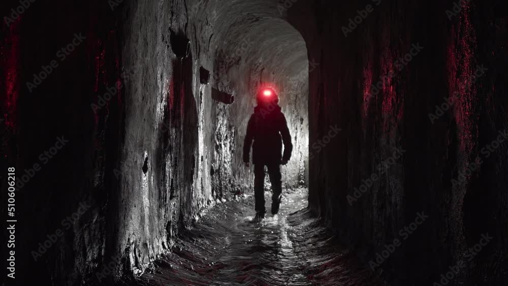 Vídeo do Stock: A man with a red lantern walks in an wet underground ...