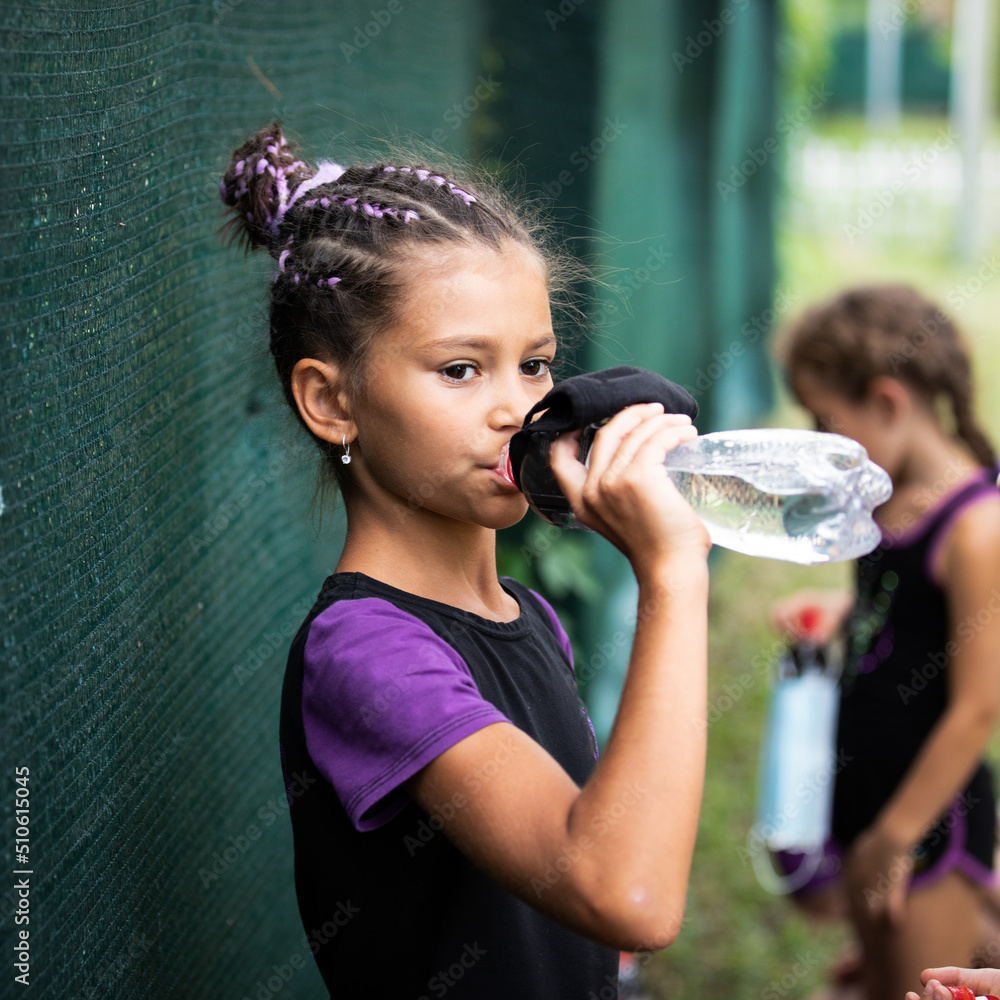 Portrait of girl trainee drinking water on training of rhythmic ...