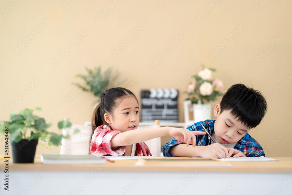 Cute girl and boy sitting in the classroom and doing homework together ...