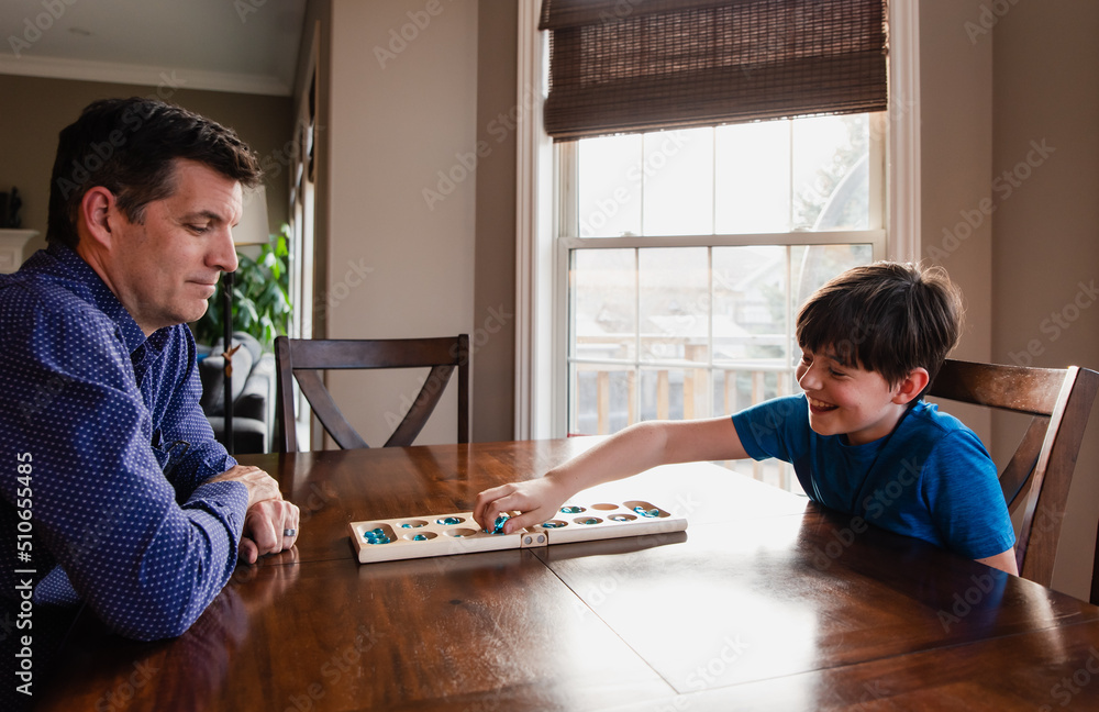 Boy and his father having fun playing a game together at home. Stock ...