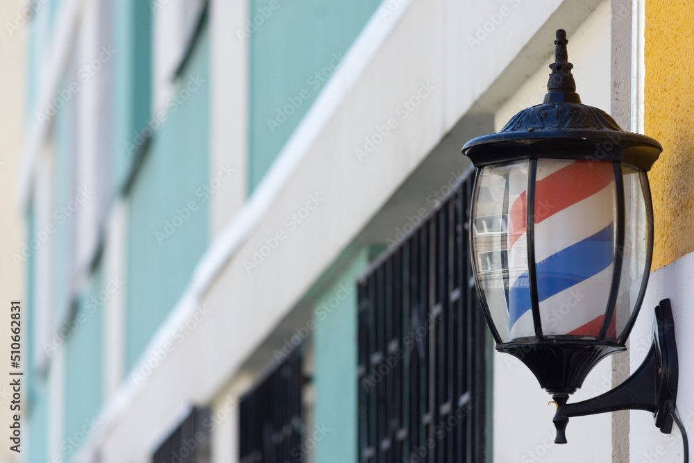 Small barber pole installed on the entrance wall to a barbershop Stock ...
