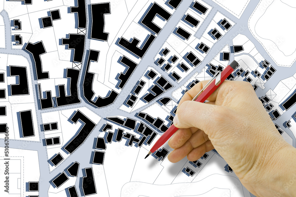 Engineer drawing an imaginary city map of territory with buildings ...