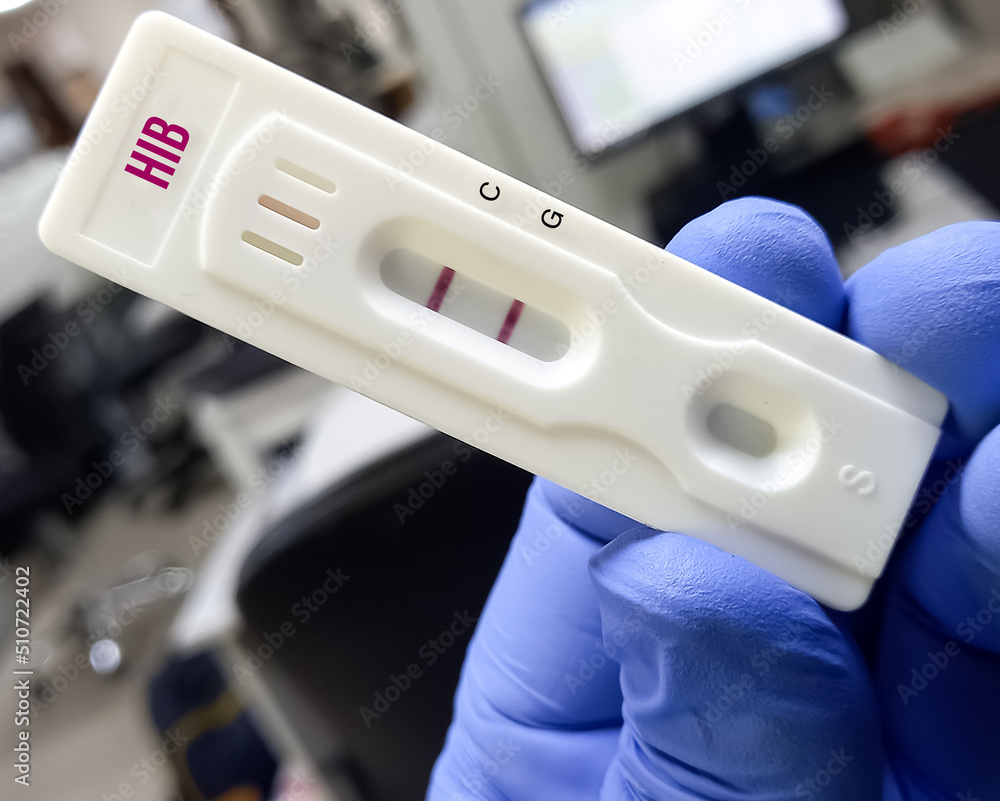 Technician holding a rapid test device for HIB(Haemophilus Influenzae ...