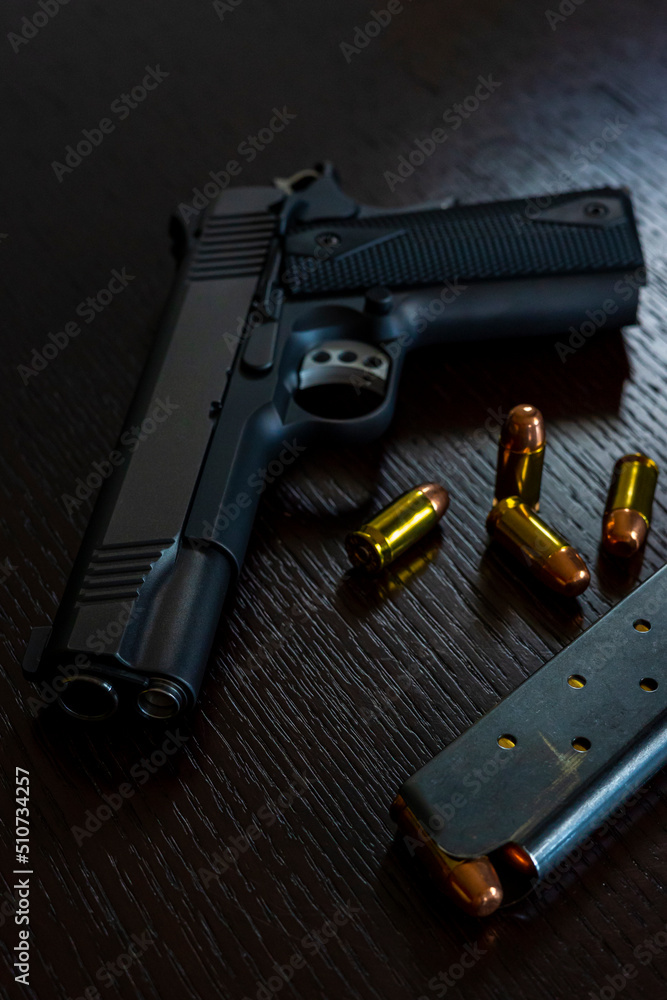 Artistic photo of a semi automatic 45 caliber handgun on a dark wood ...