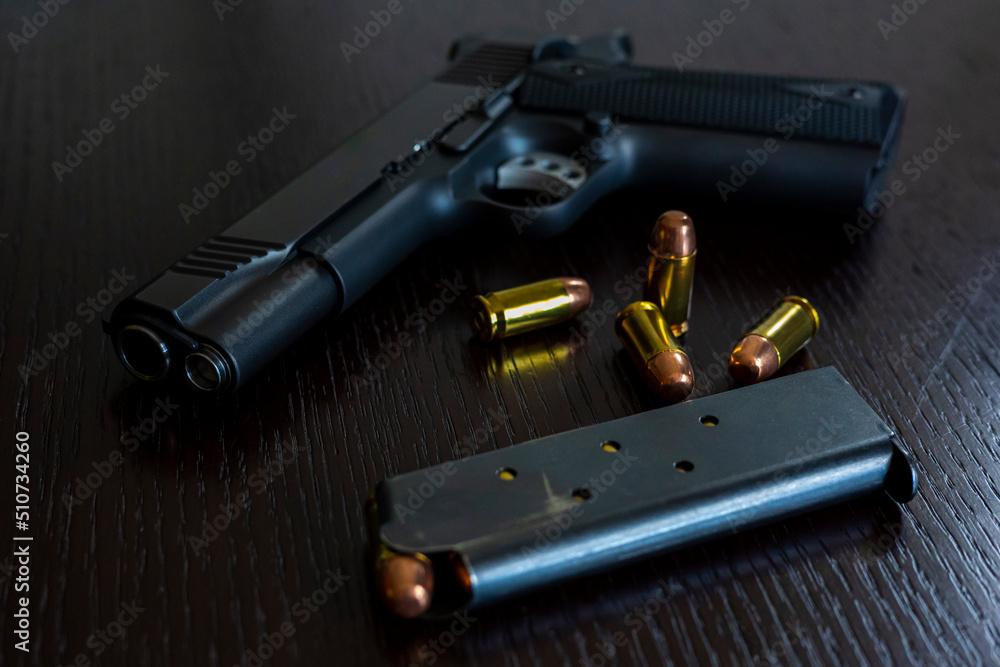 Artistic photo of a semi automatic 45 caliber handgun on a dark wood ...