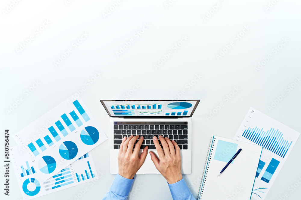 Top view of business man using laptop for preparing reports. Many blue ...