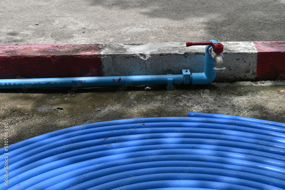 Blue rubber hose coiled on the ground. Blue rubber hose background ...