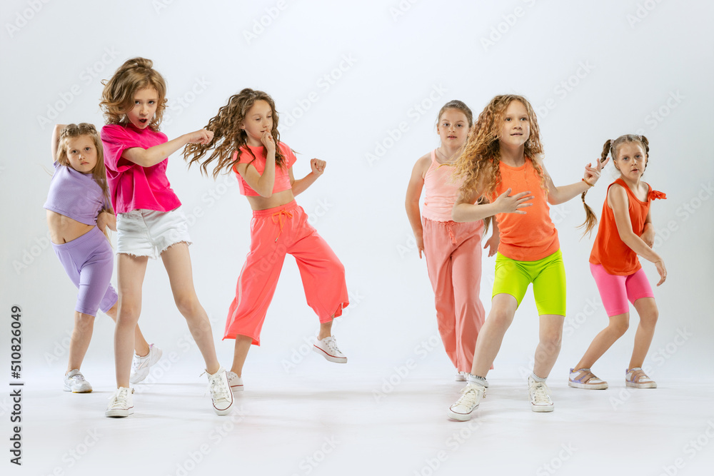 Happy, sportive little girls, kids in bright colorful clothes dancing ...