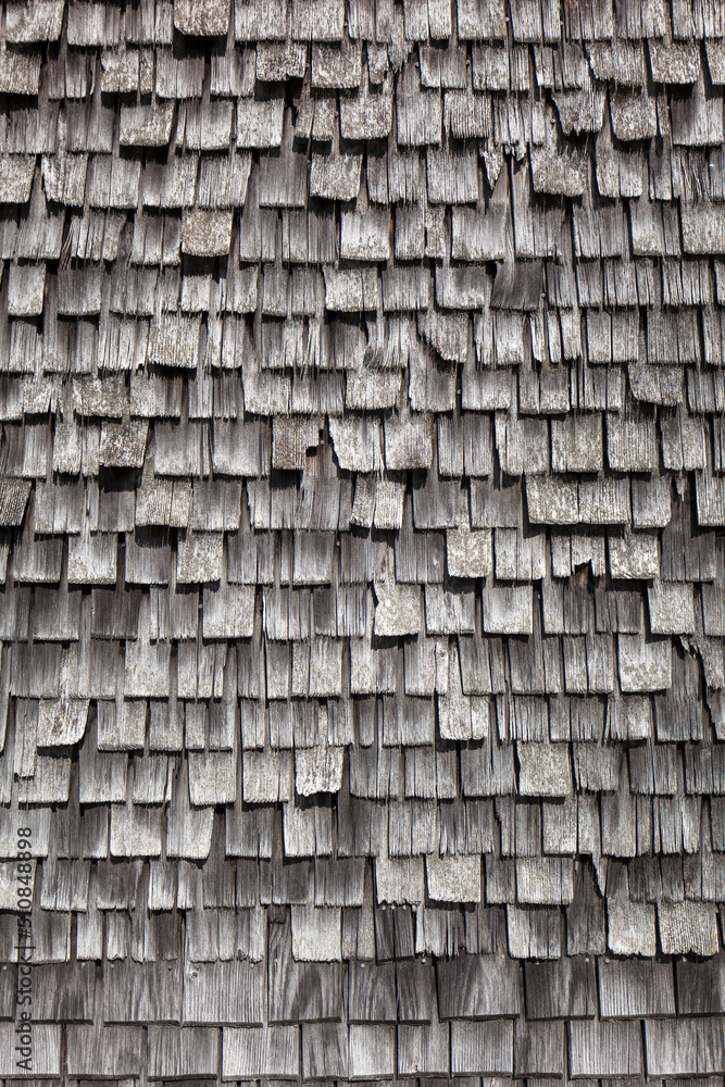 Facade clad with wooden shingles. Schingles on building. Fassade ...