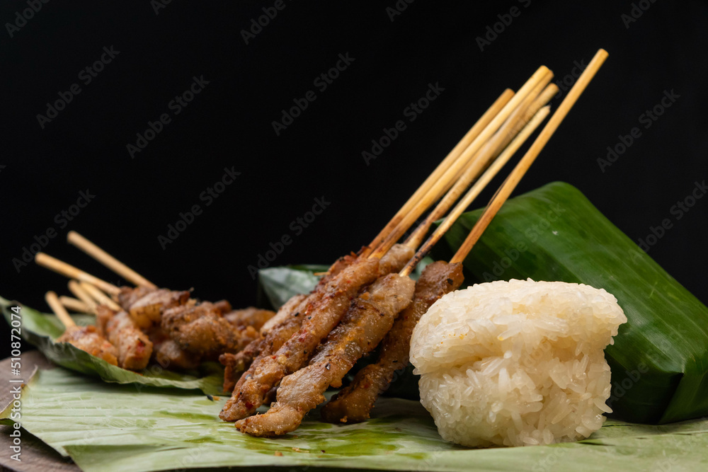 front view of grilled skewered pork(Moo Ping) with white sticky rice ...