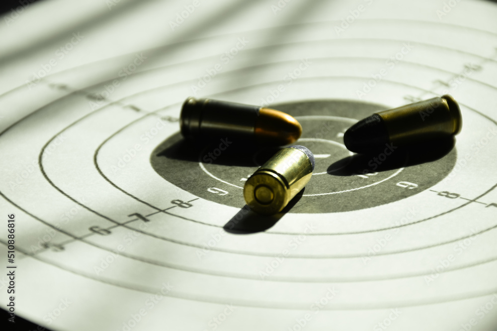 9mm pistol bullets on shooting target paper, soft and selective focus ...