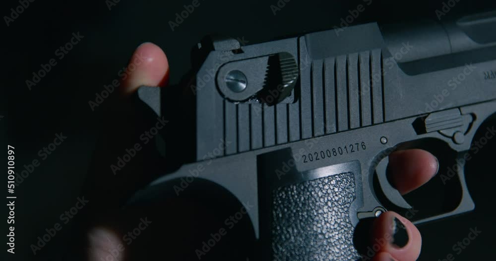 Criminal woman with black nails prepares to shoot with gun at night ...