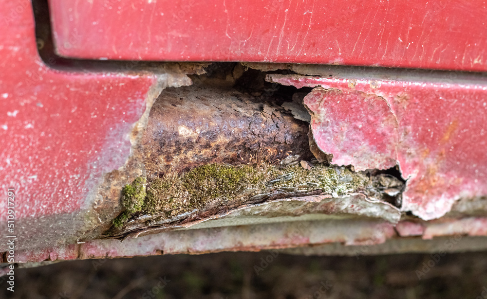 Rusty driver's door sills. Corrosion of the body of a red old car after ...