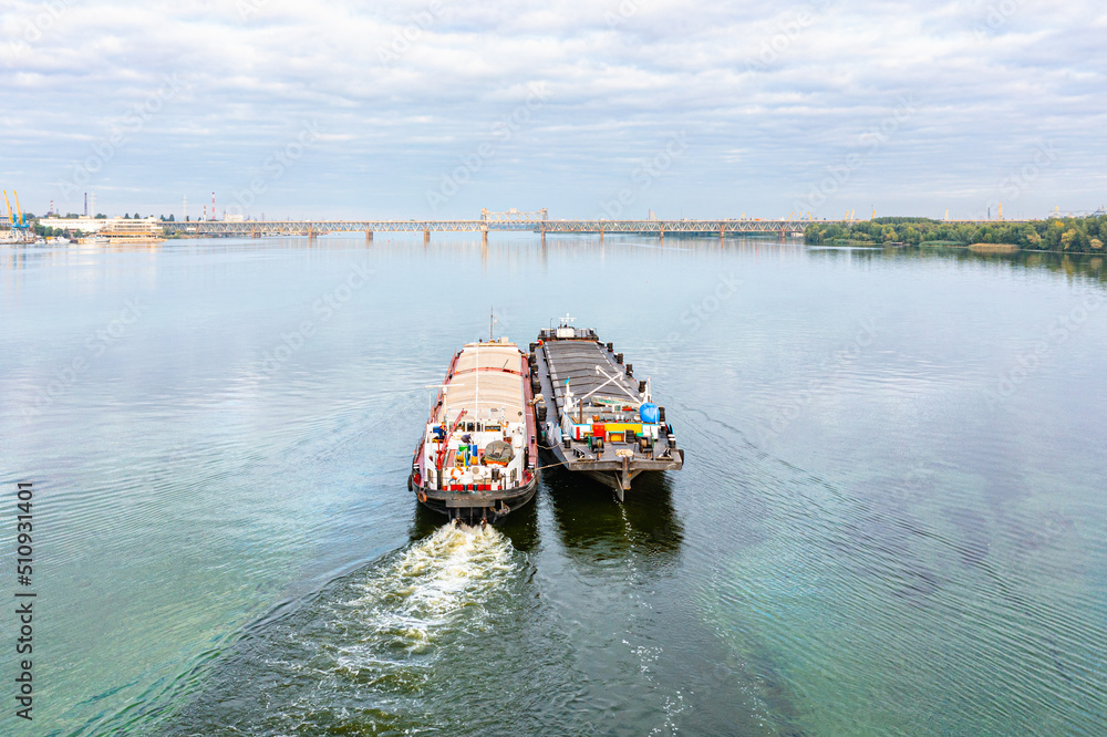 Two barges loaded with grain are sailing down the river to a commercial ...