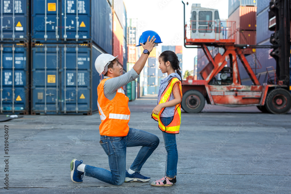 Father and little daughter wearing a safety helmet at Container cargo ...
