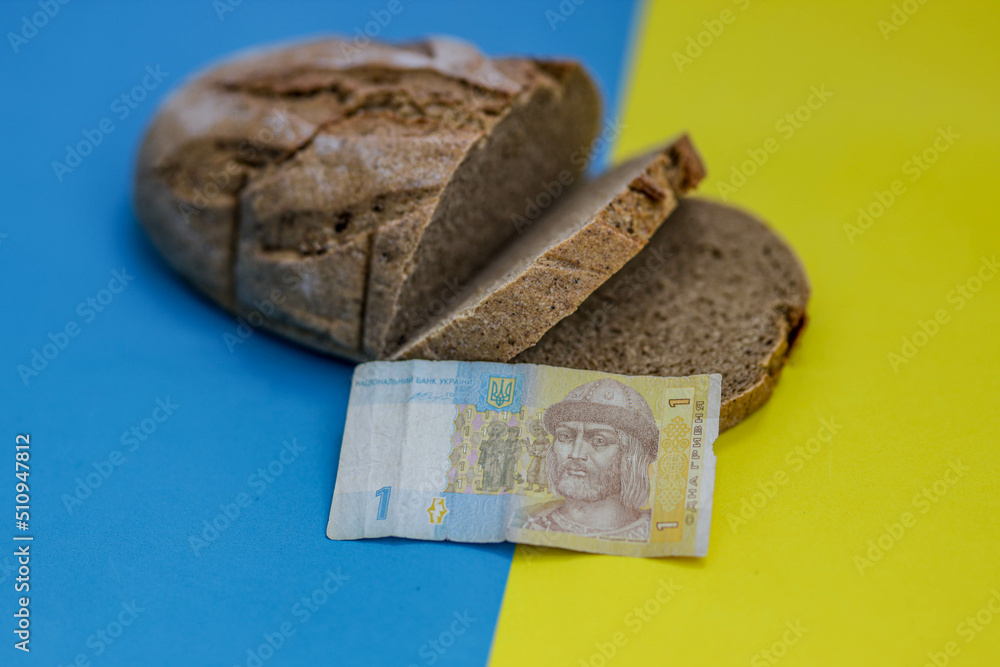 Homemade baked wheat loaf of bread on national Ukrainian flag ...