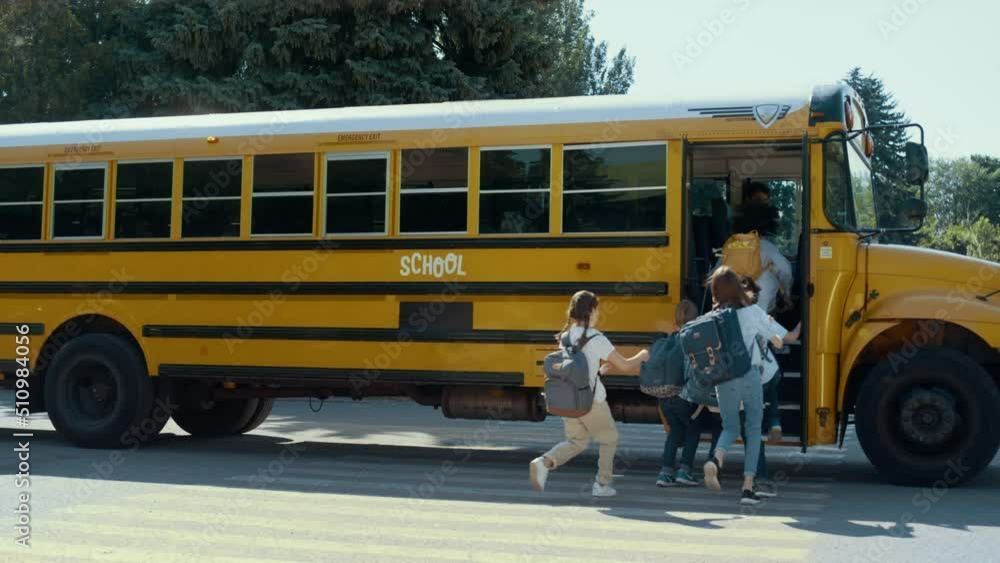Energetic teen students rushing into school bus. Happy schoolchildren ...