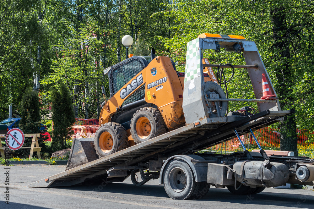 Skid steer loader on a tow truck. tow truck with sliding platform Stock ...