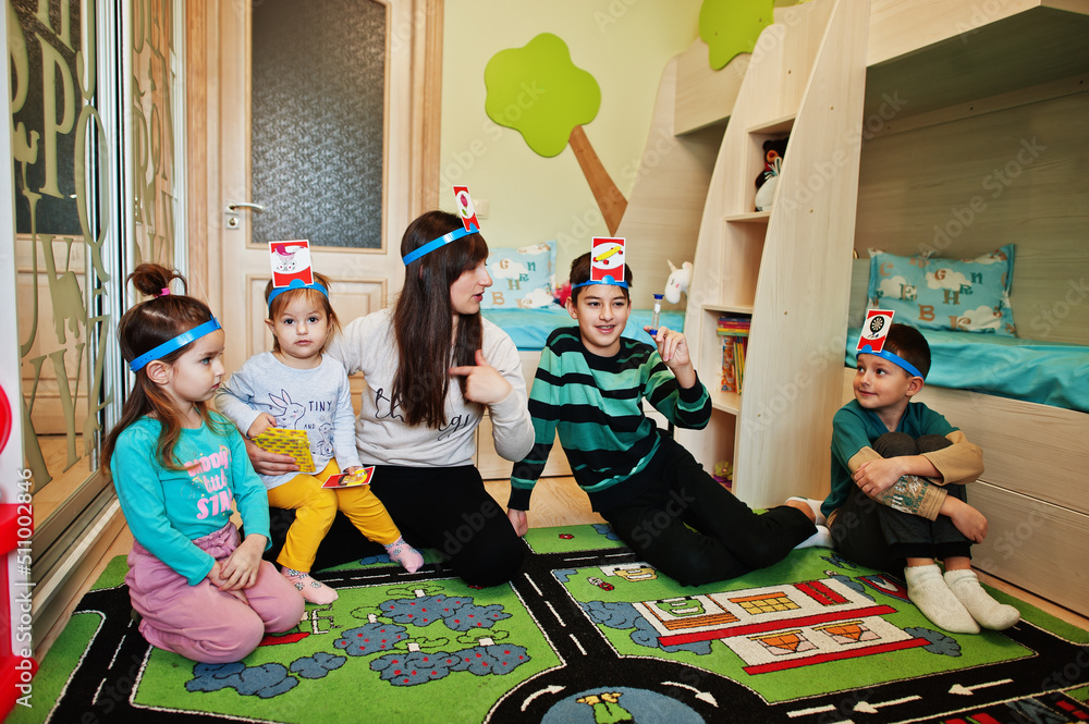 Happy family with four kids playing game guess who while having fun at ...