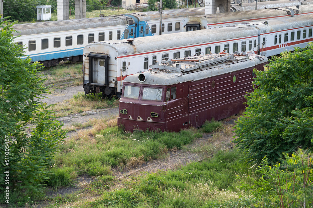 Abandoned soviet locomotive and passenger wagons on railroad tracks ...