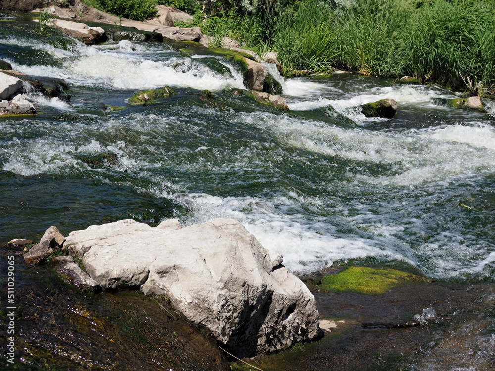 Fast flowing water in the mountain river, water spray from the waves ...