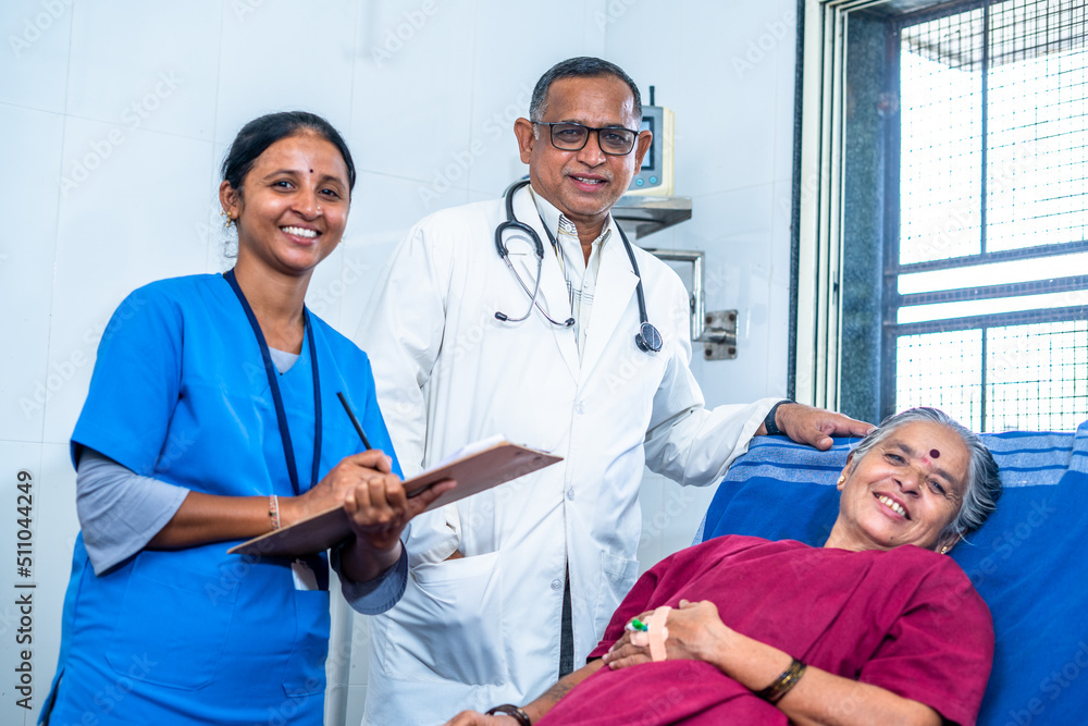 Happy smiling doctor, patient and nurse looking at camera during ward ...