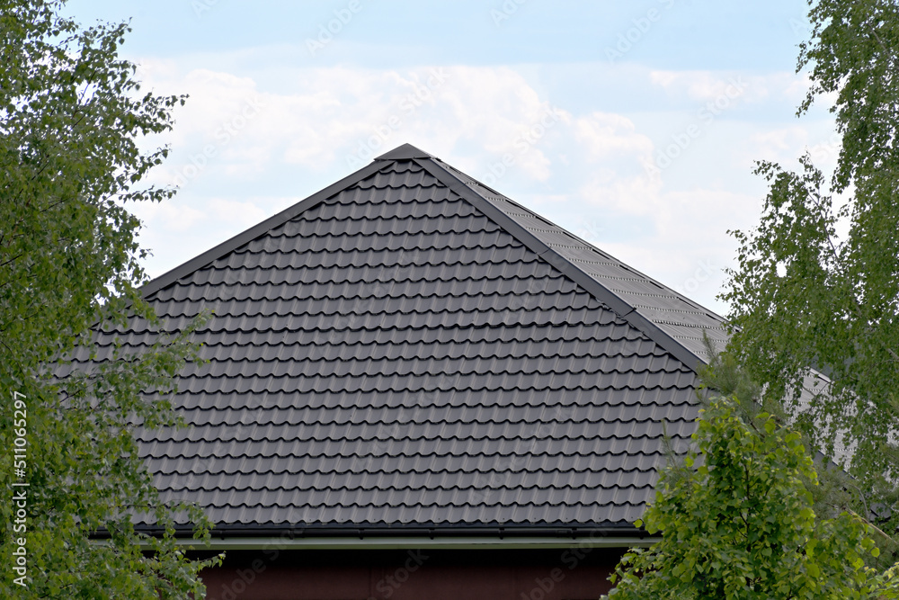 Fragment of a four-pitched roof of a residential building on a summer ...