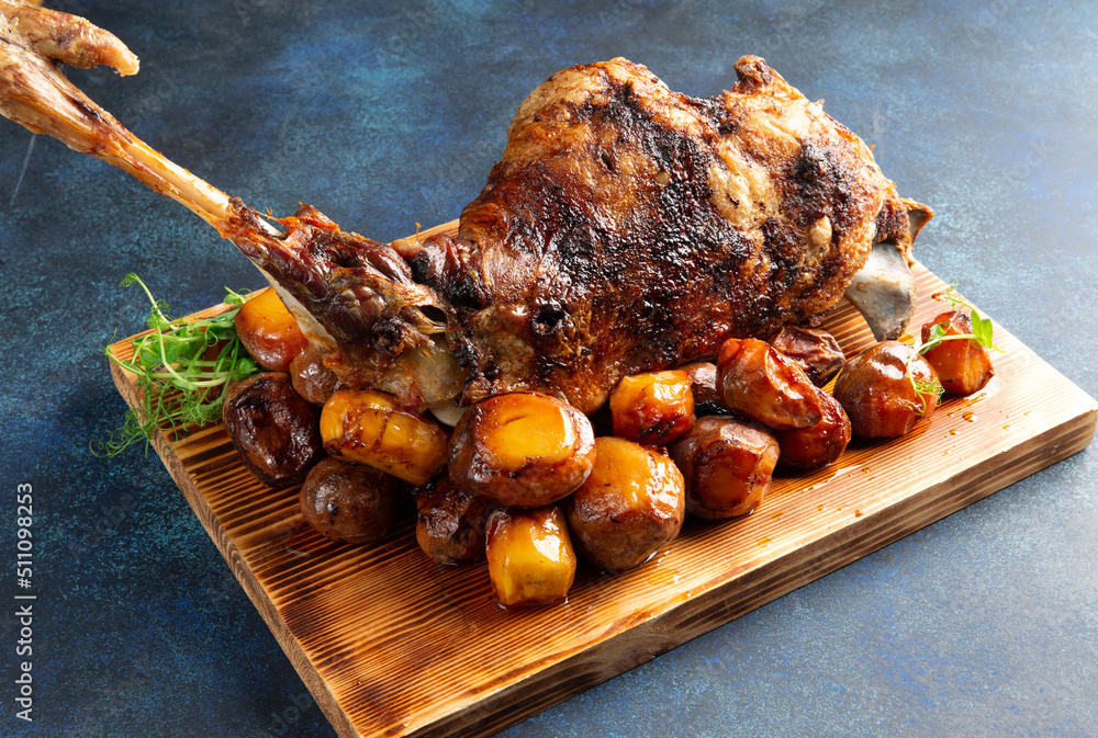 Cooked leg of lamb and new potatoes. On a gray background. Stock Photo ...