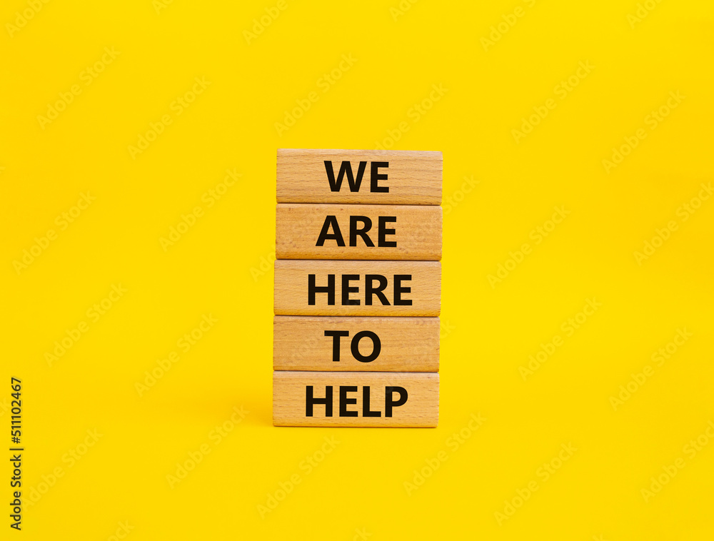 We are here to help symbol. Concept words we are here to help on wooden ...